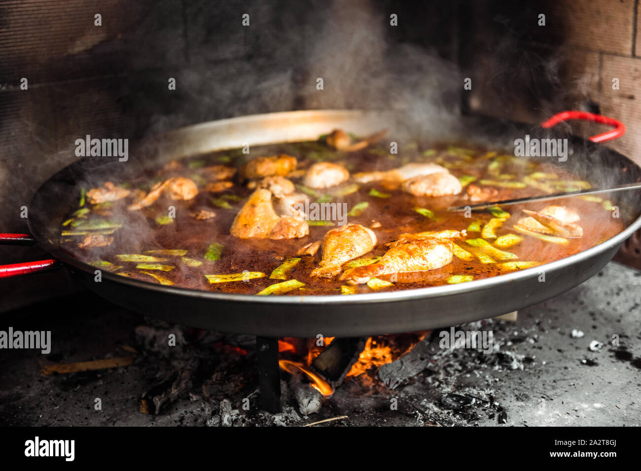 Cooking and making a traditional Spanish Paella over open fire ...