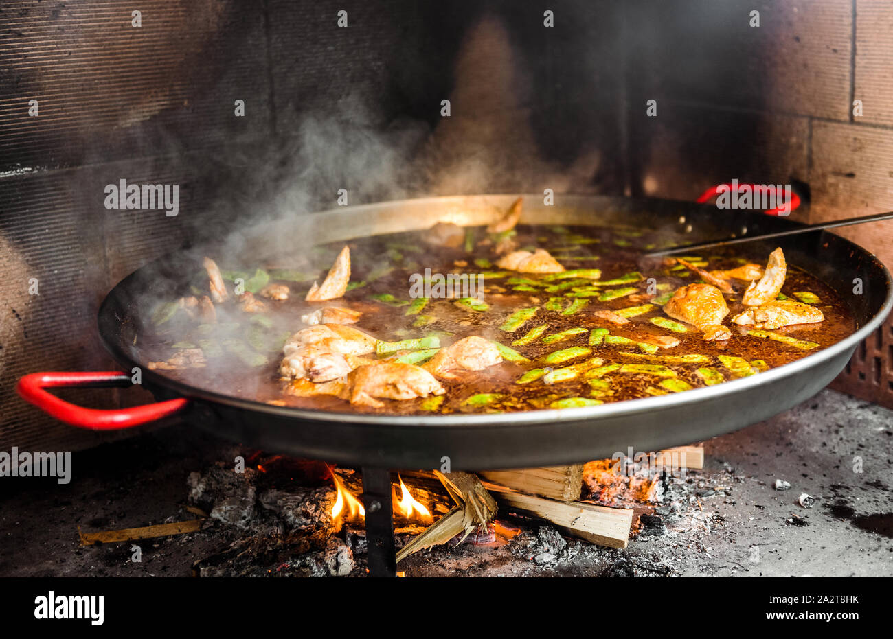 Cooking and making a traditional Spanish Paella over open fire ...