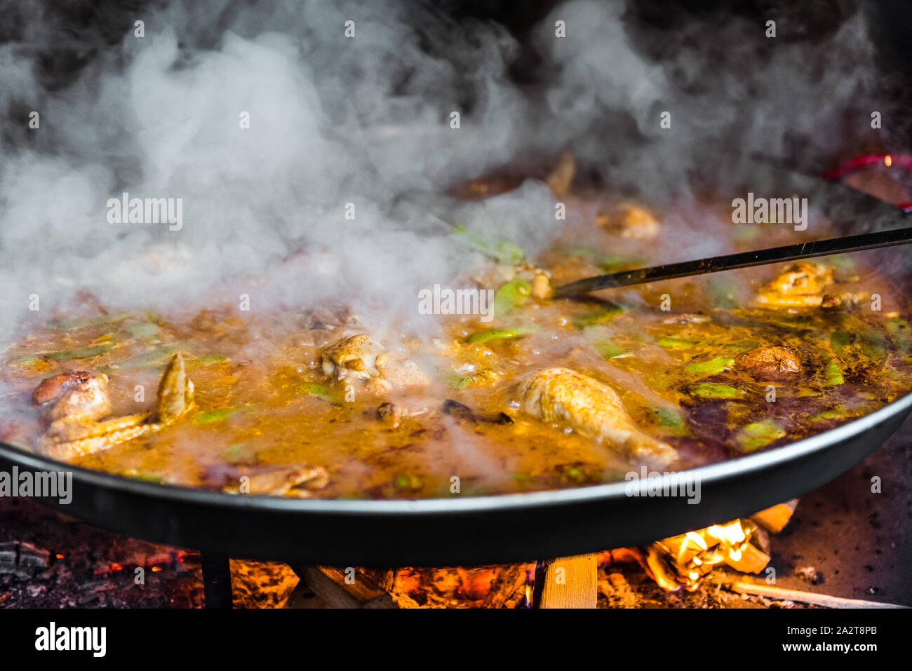 Cooking and making a traditional Spanish Paella over open fire ...