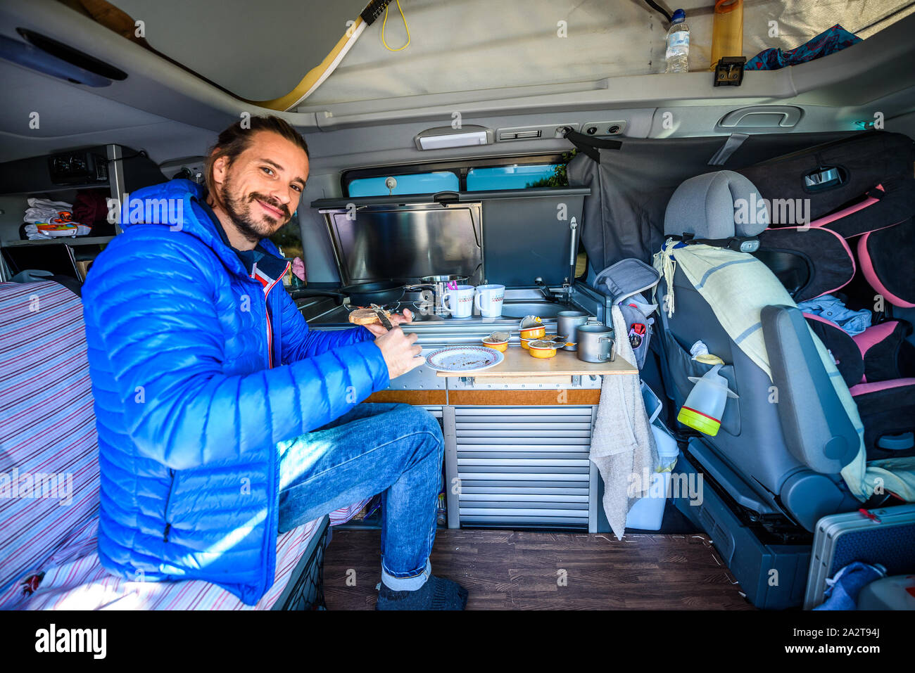 Making breakfast or lunch in campervan, motorhome or RV. Young hipster ...