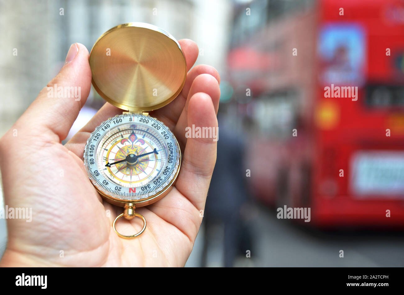 Compass in the hand against a city street Stock Photo - Alamy