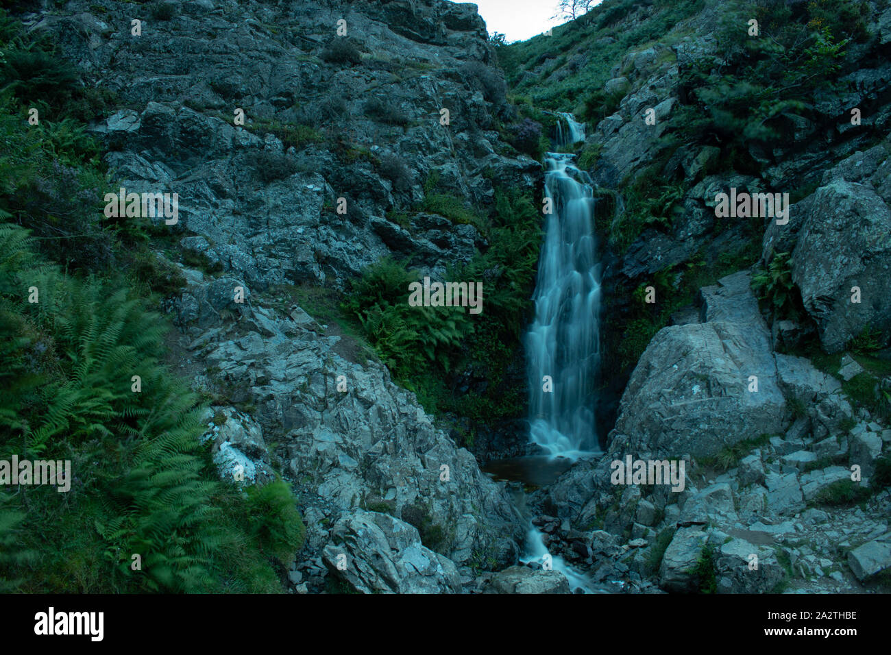 Carving mill valley waterfall in a rocky landscape with green ...