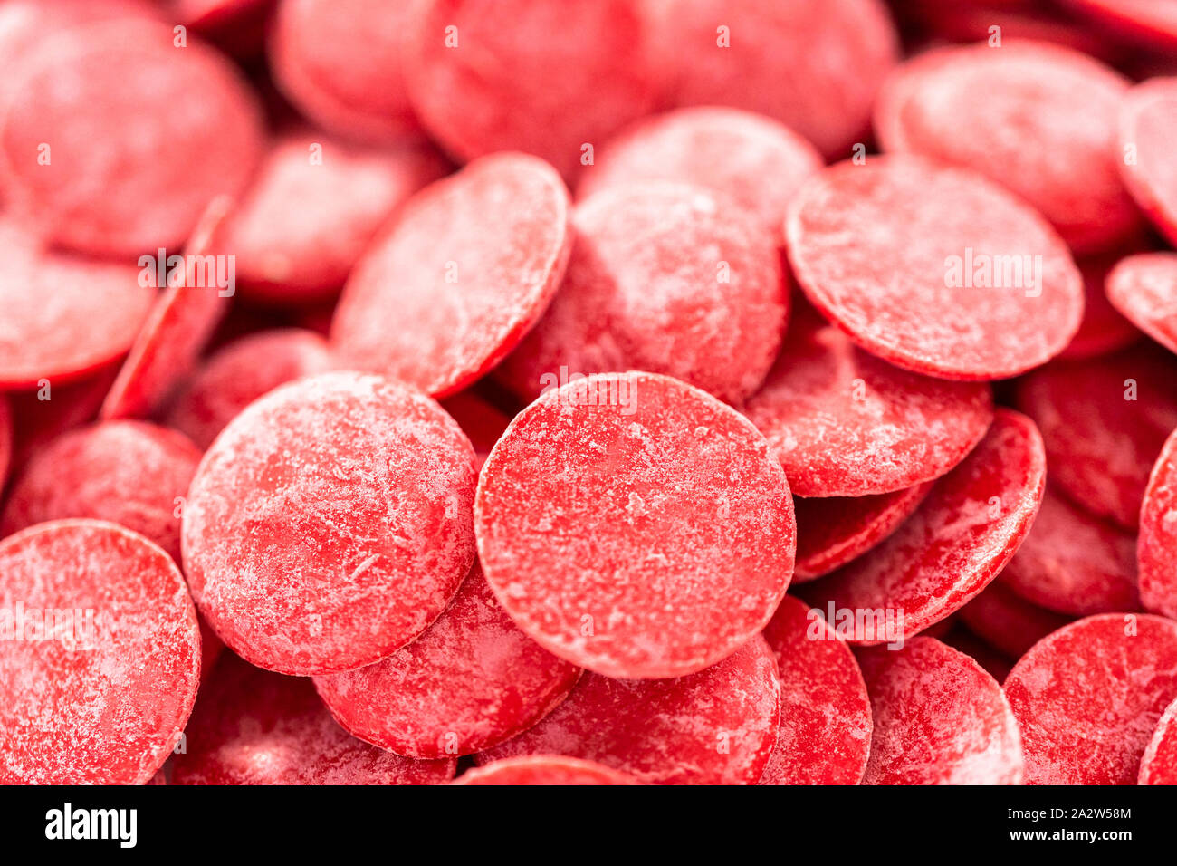 Red round chocolate chips for melting chocolate shapes on a white ...