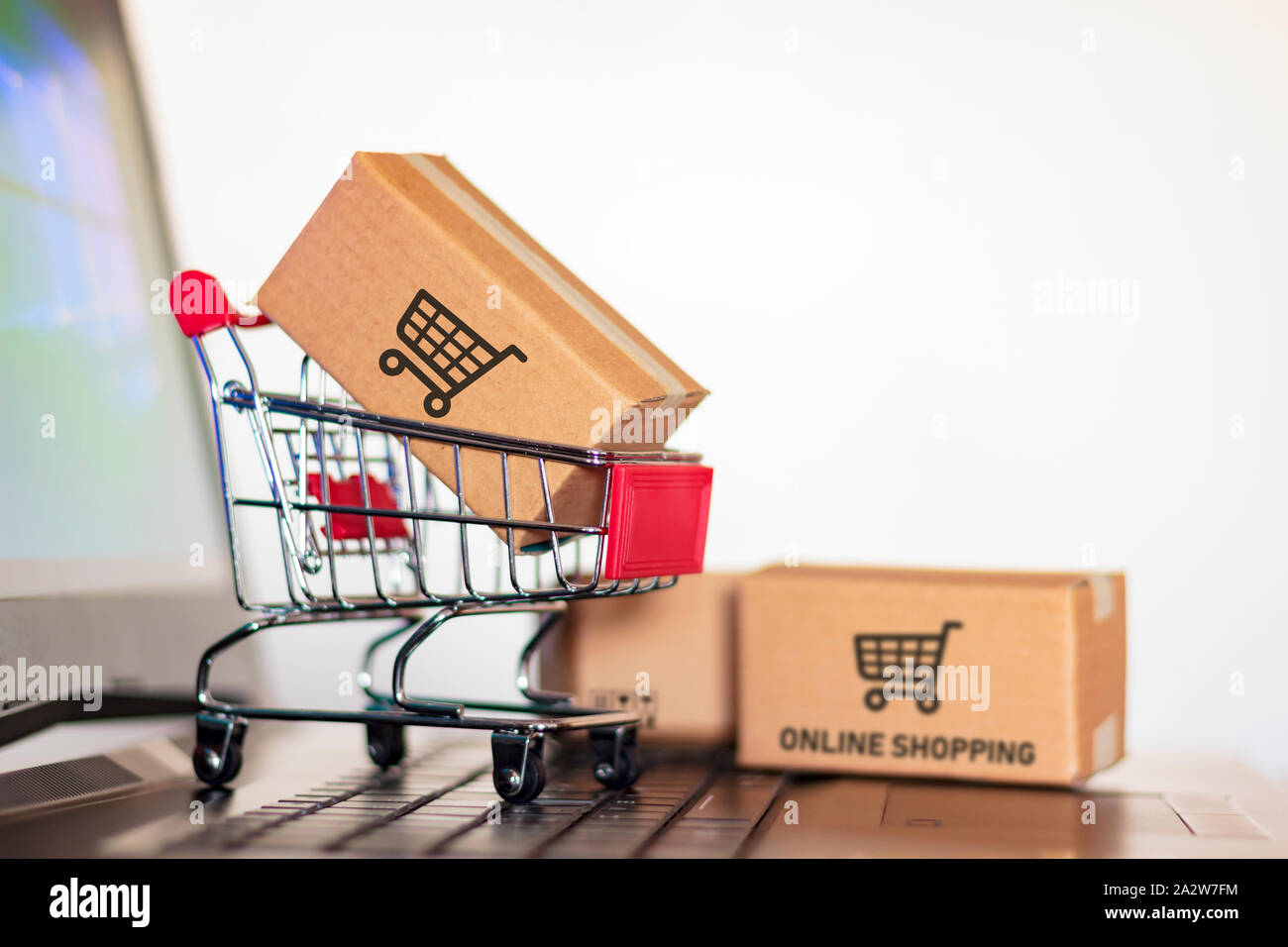 Trolley with cartons on computer. Online shopping, e-commerce and ...