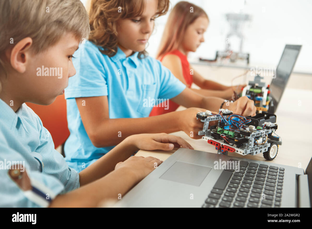Robotics. Children sitting having class making robots concentrated ...
