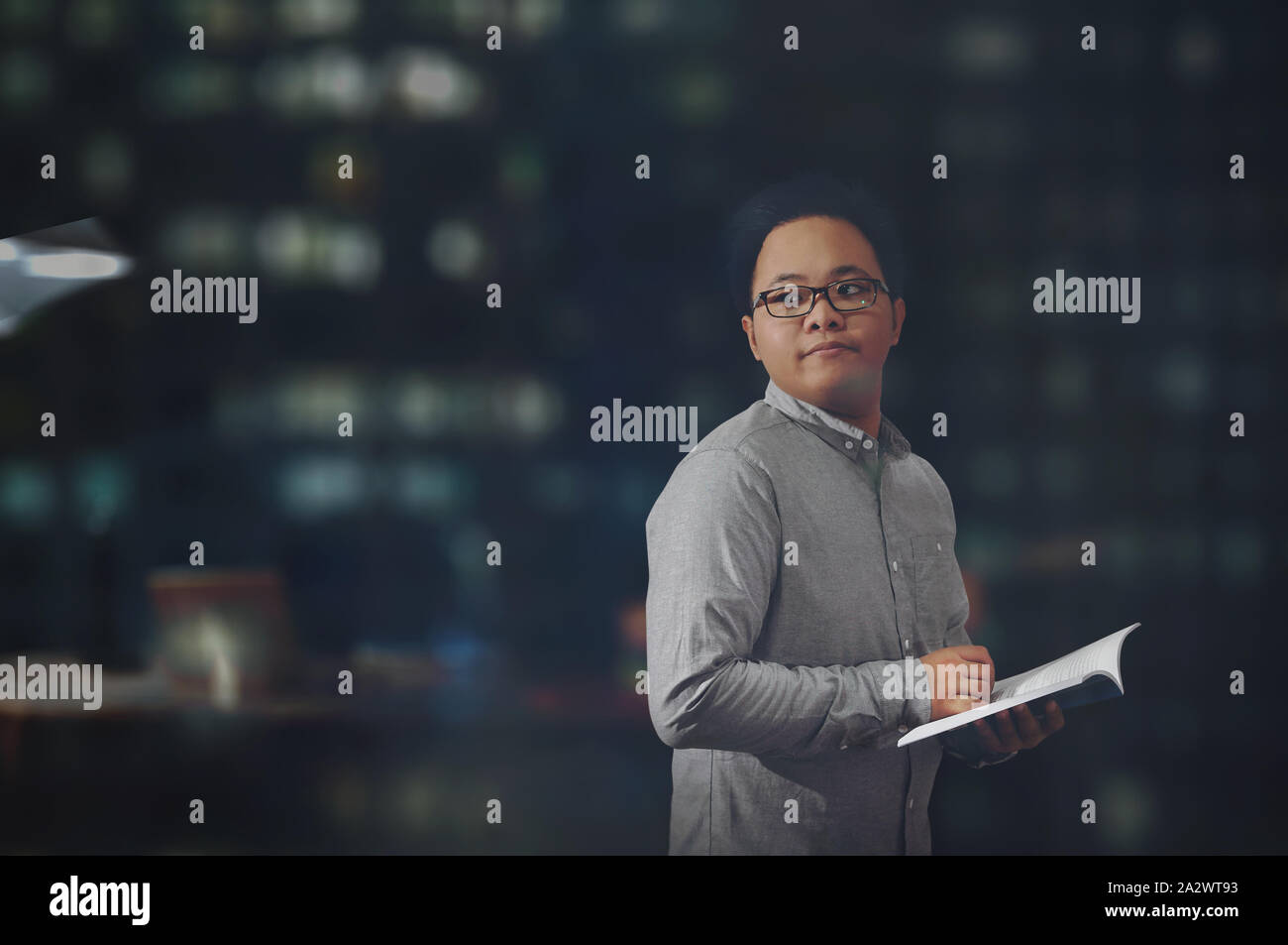 Young man in long sleeves and glasses inside an office building at ...