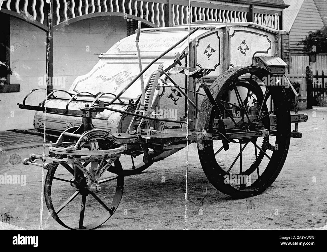 Negative - circa 1900, A reaper which has been decorated with foliage ...