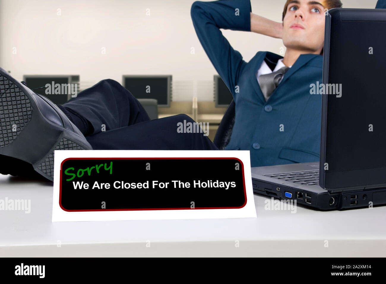 Businessman on a desk with a closed sign using a computer to type a ...