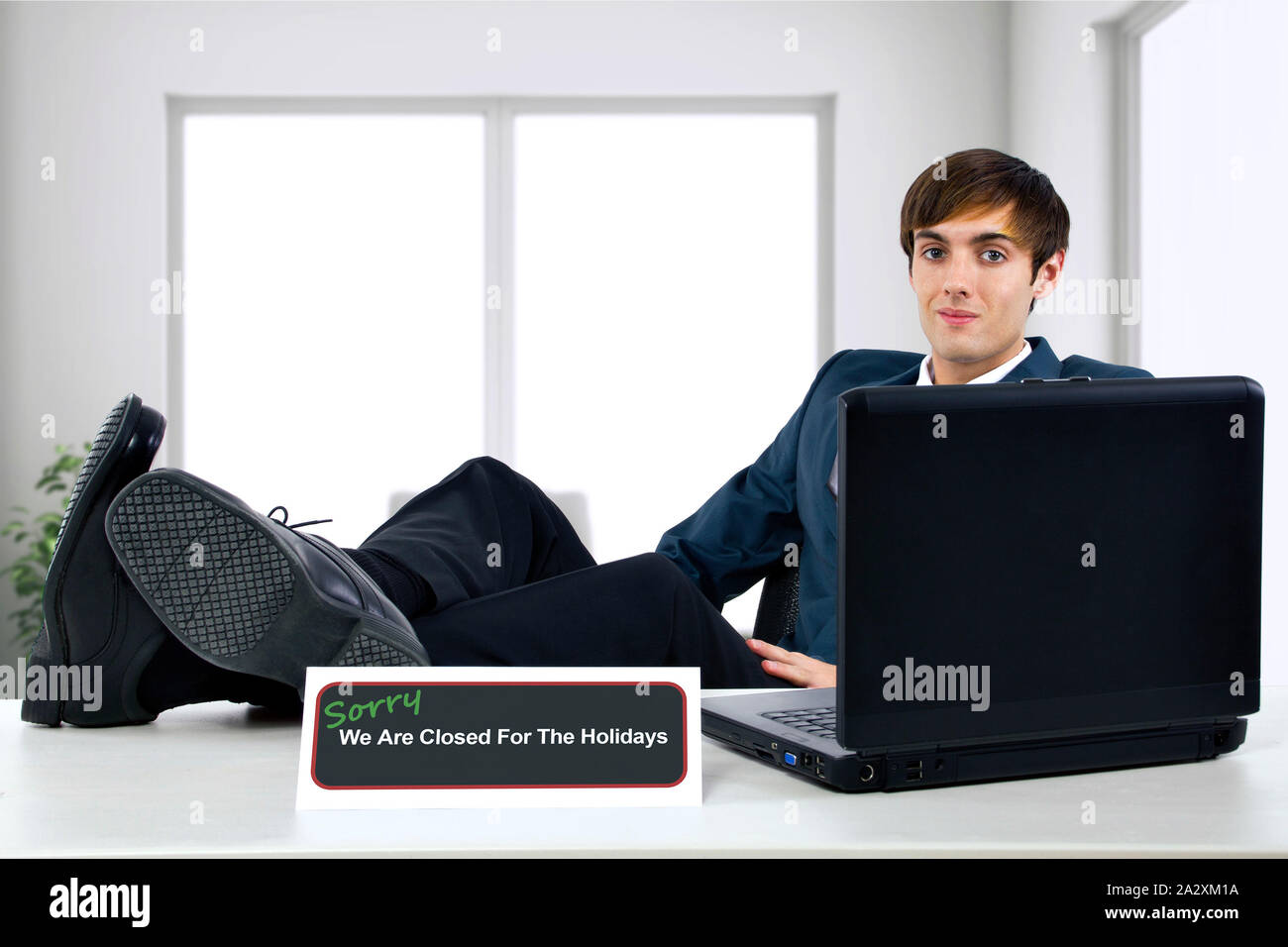 Businessman on a desk with a closed sign using a computer to type a ...