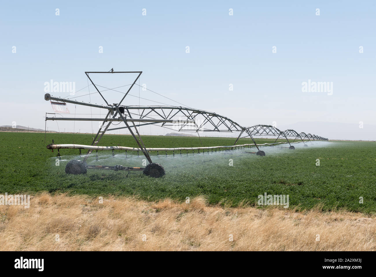 Rolling irrigation sprinkler at work along the road carrying U.S ...