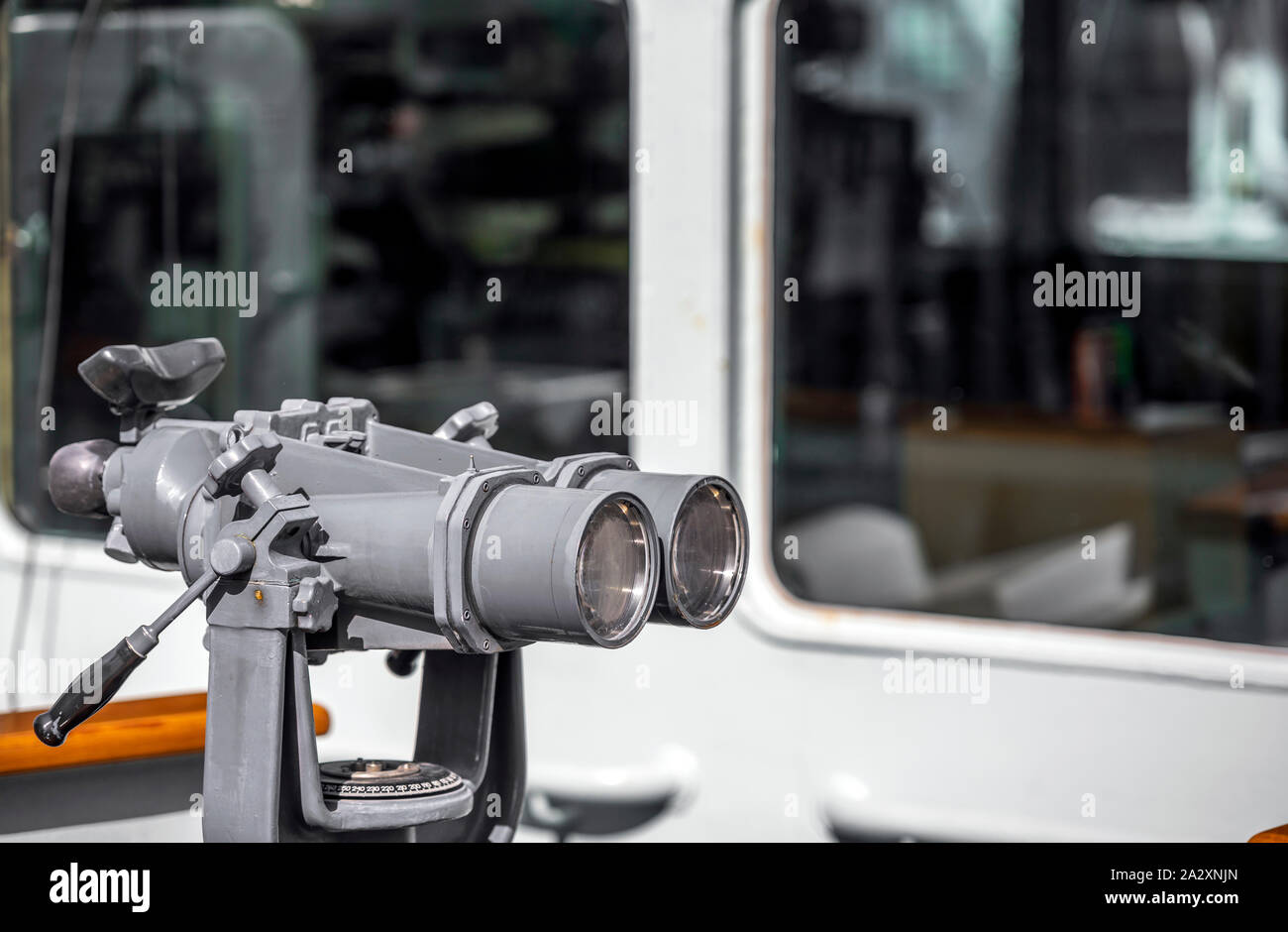 Repeatedly magnifying marine naval binoculars mounted on a bracket on ...