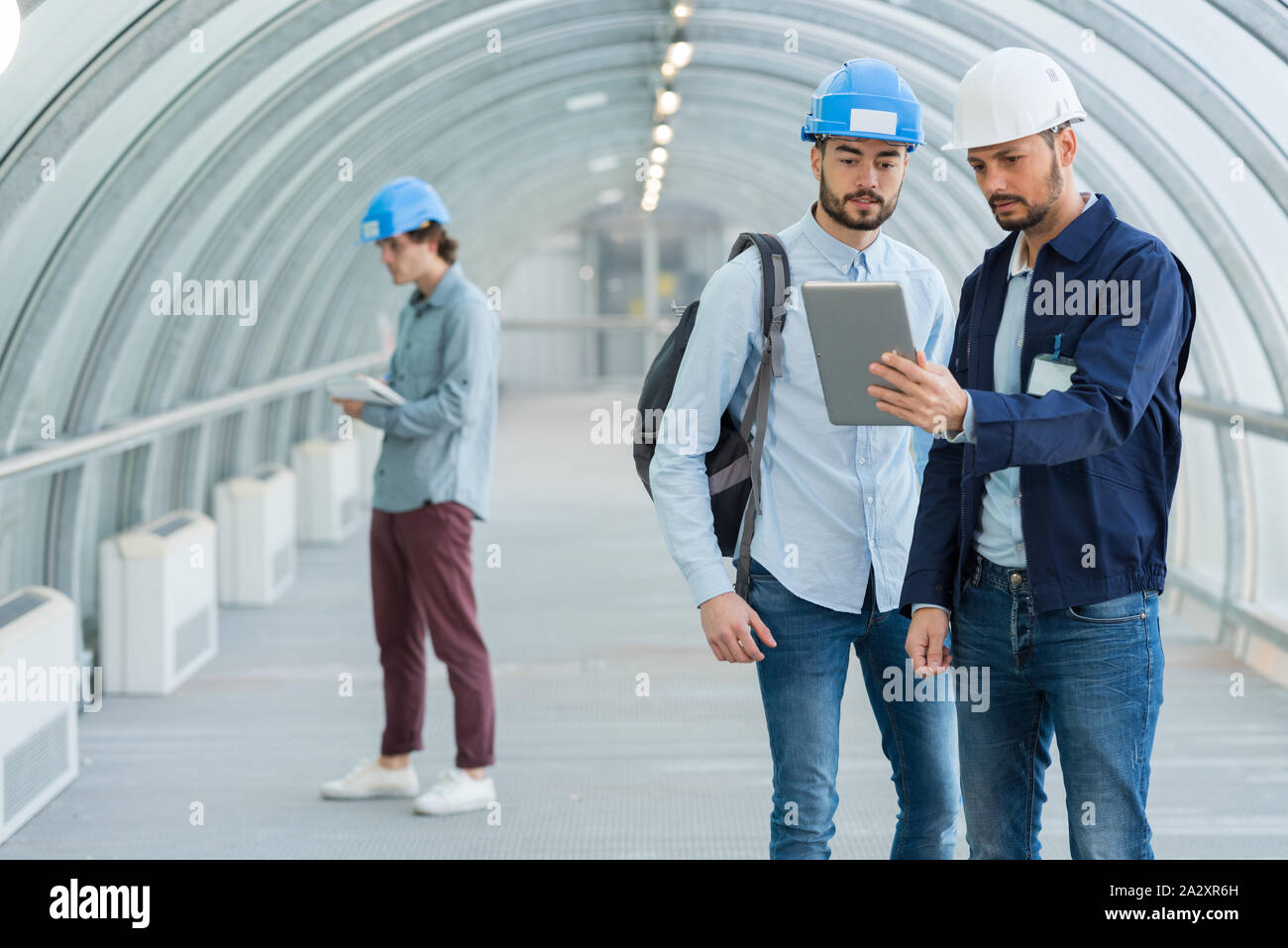 blue-collar workers looking at tablet Stock Photo - Alamy