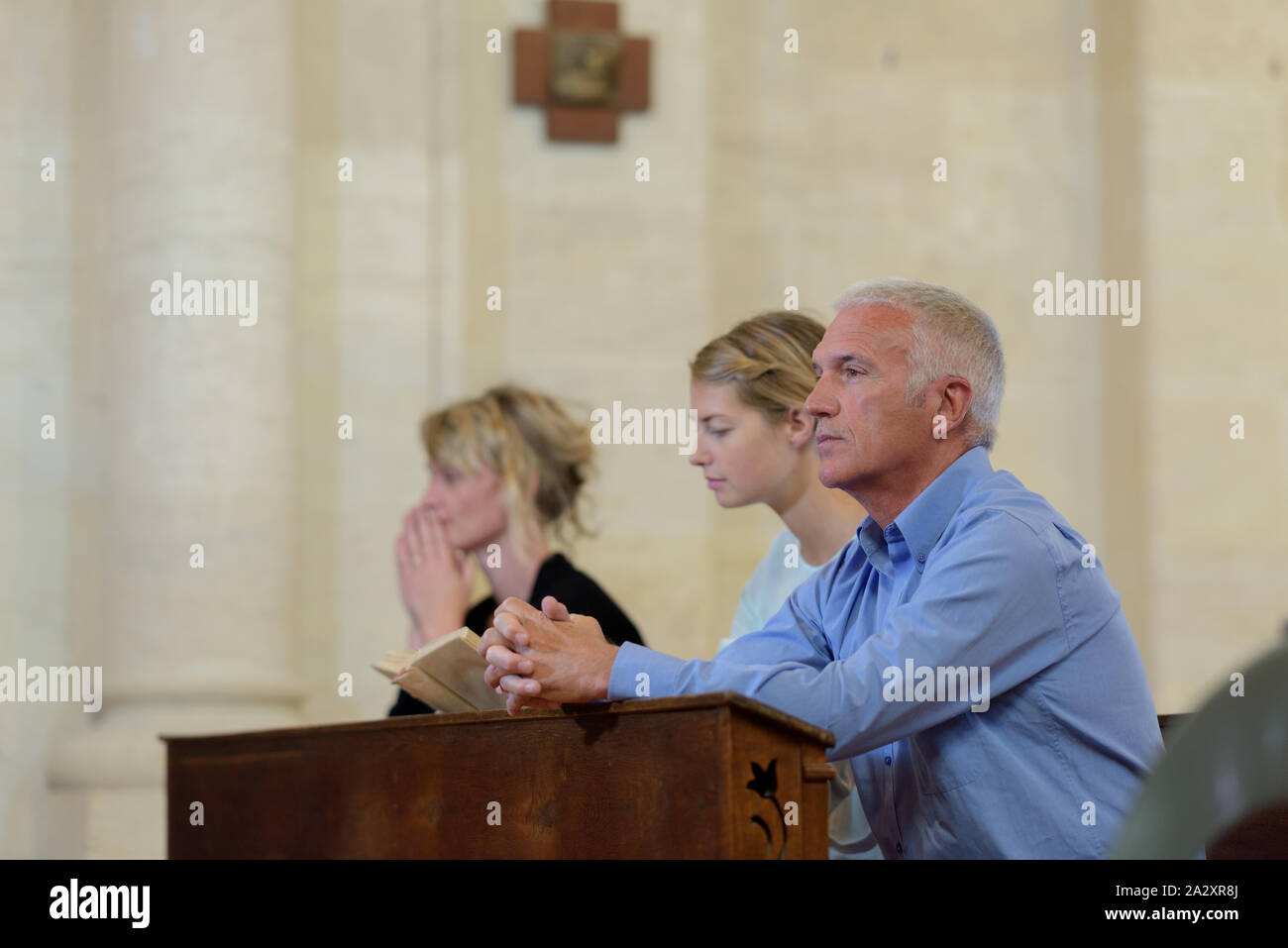 sad people praying in church Stock Photo - Alamy