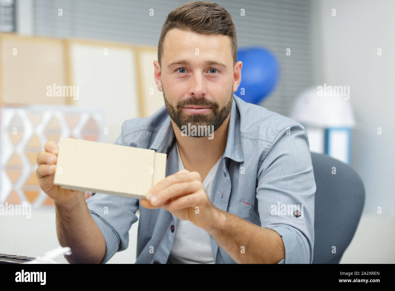 happy sales man showing wood samples in office Stock Photo - Alamy