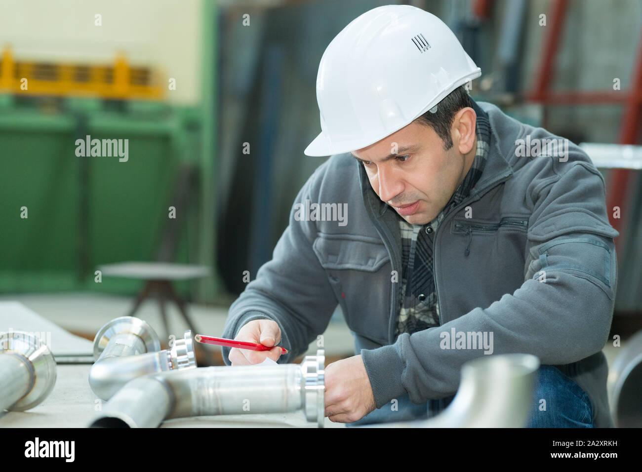 male worker holding pipes in a factory Stock Photo - Alamy