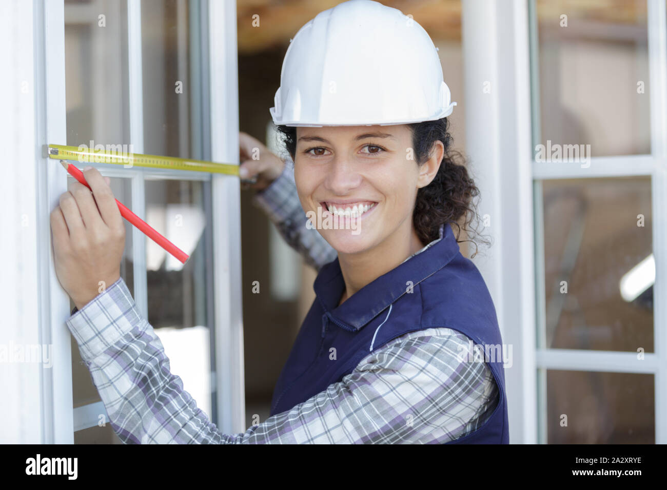 a female builder measuring window Stock Photo - Alamy