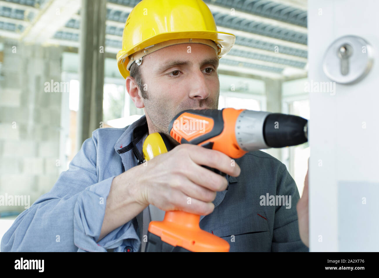 builder drills a wall with a drill Stock Photo - Alamy