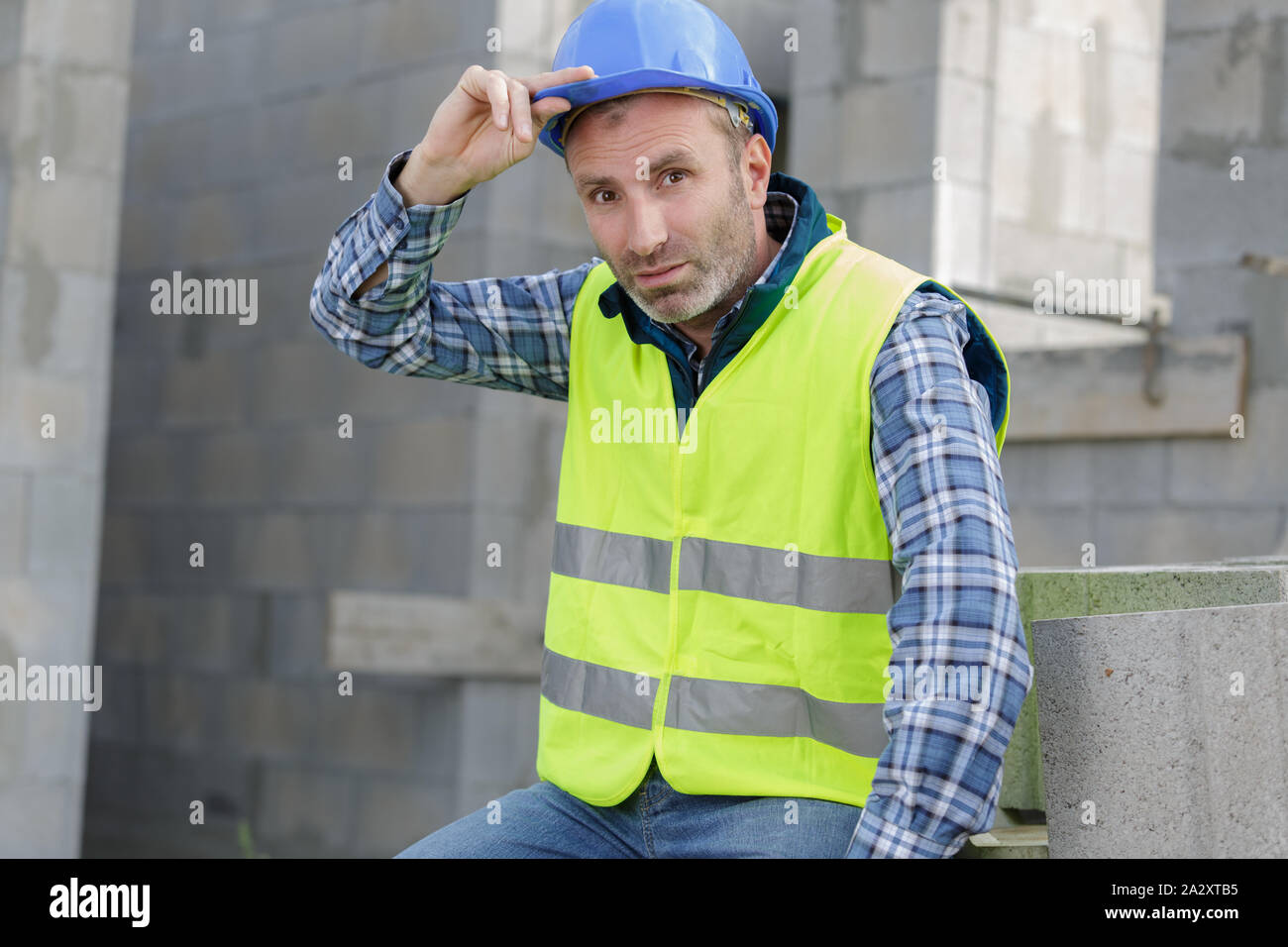 tired builder holding his helmet Stock Photo - Alamy