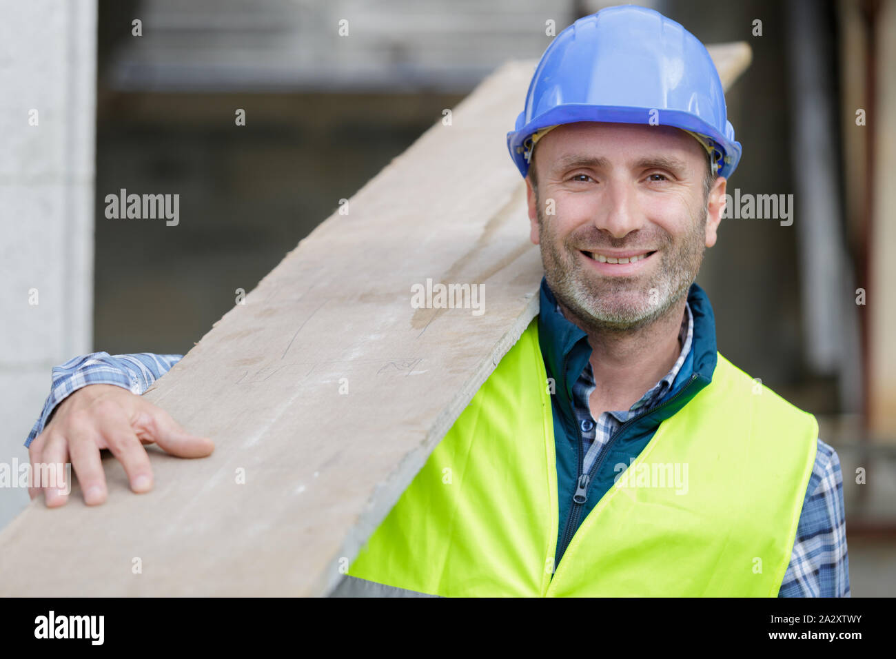 man as builder carrying wood and working Stock Photo - Alamy