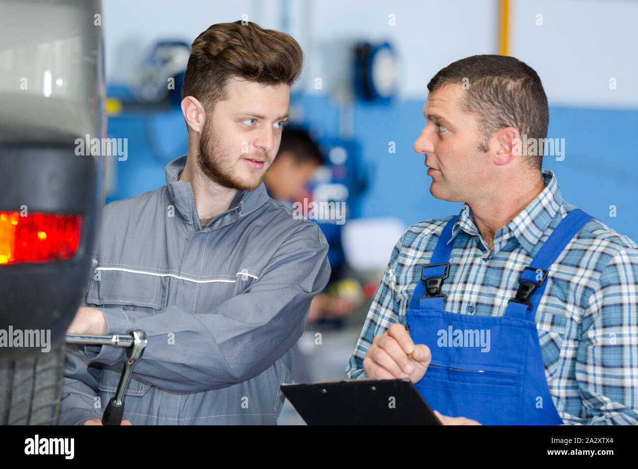 mechanic supervisor checking workers work Stock Photo - Alamy