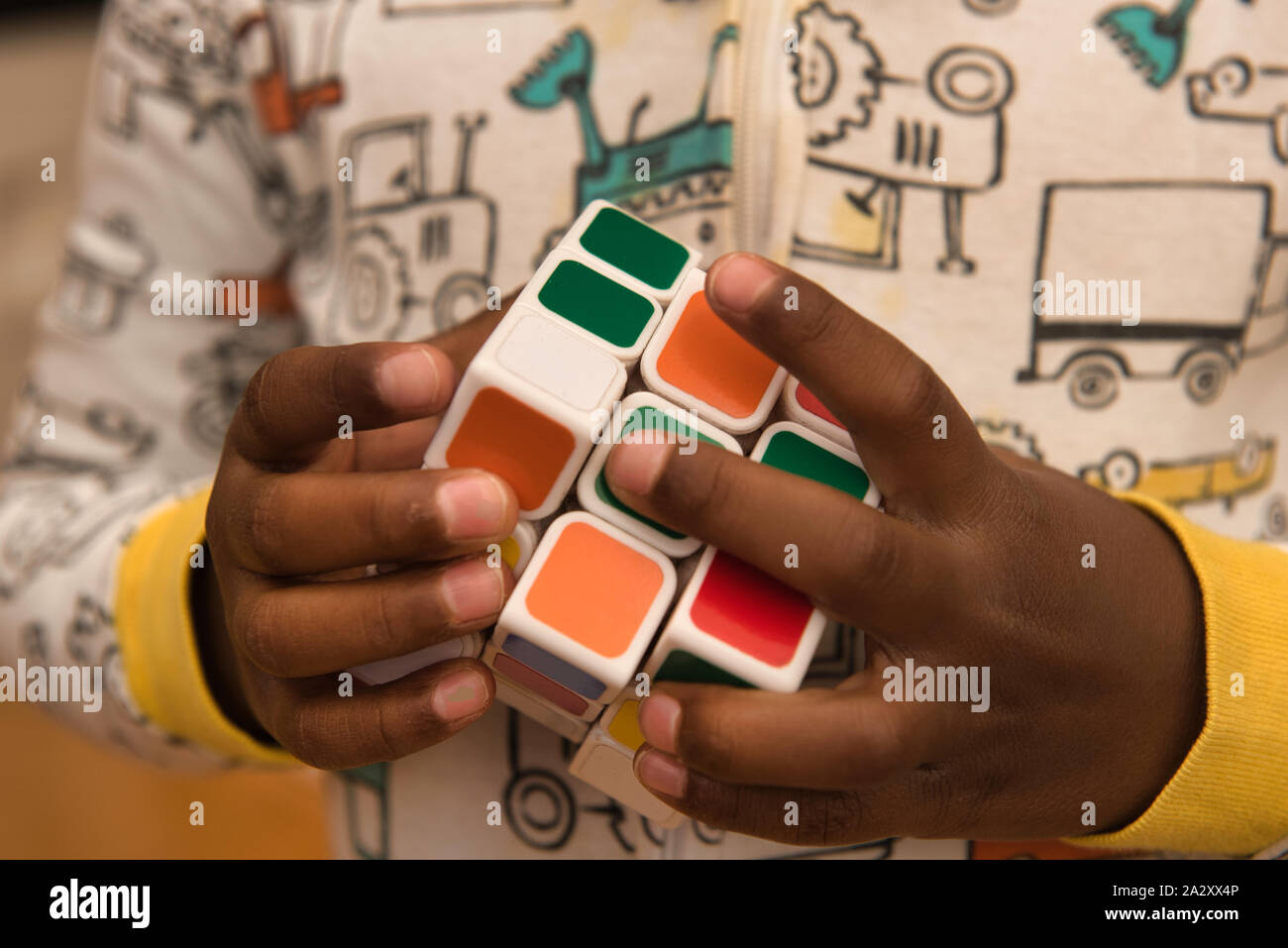 Hands of toddler in Pajamas solving white Rubik’s cube Stock Photo - Alamy