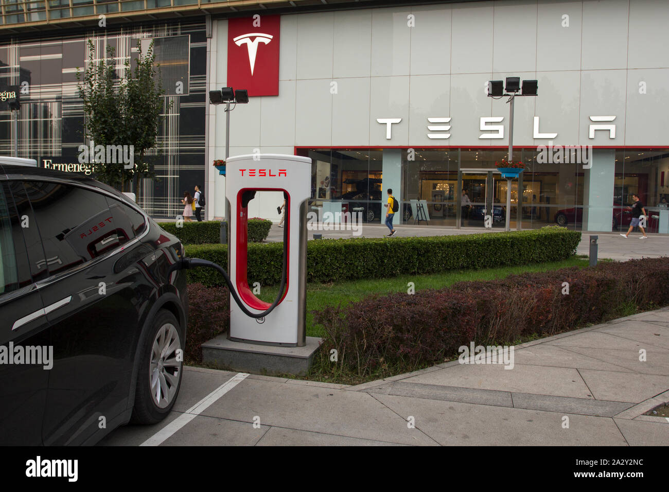 A Tesla electric car is being charged at a Tesla charging station ...