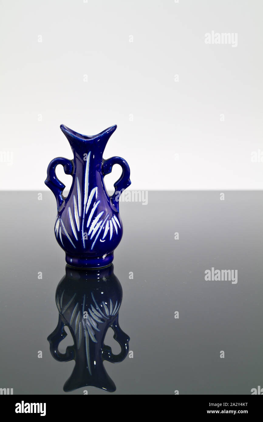 blue little vase on reflective surface and white background Stock Photo ...