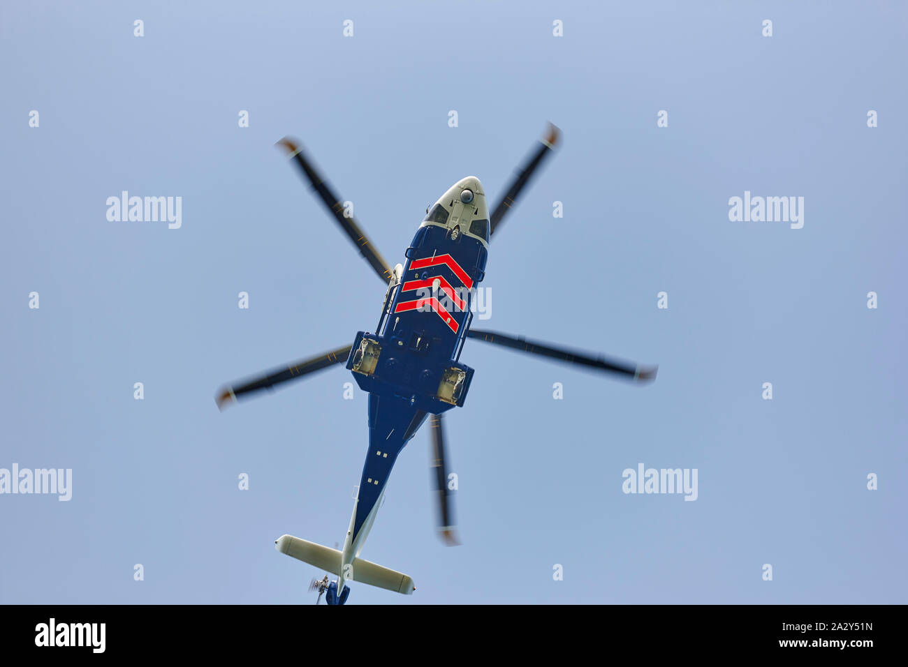 Helicopter flying under a blue sky from below. Air transport Stock ...
