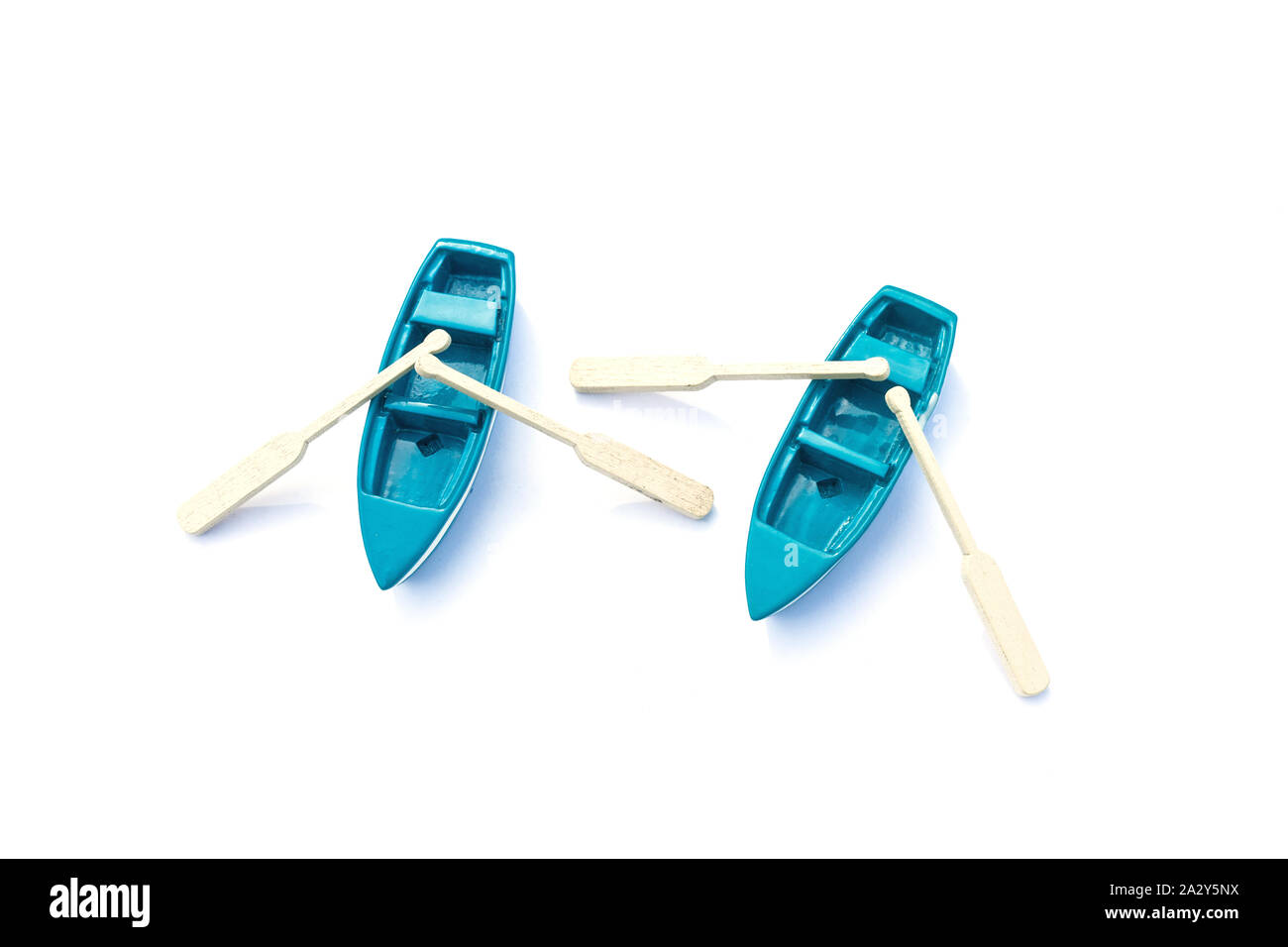 pair of blue miniature boats with oars isolated with shadow on a white ...