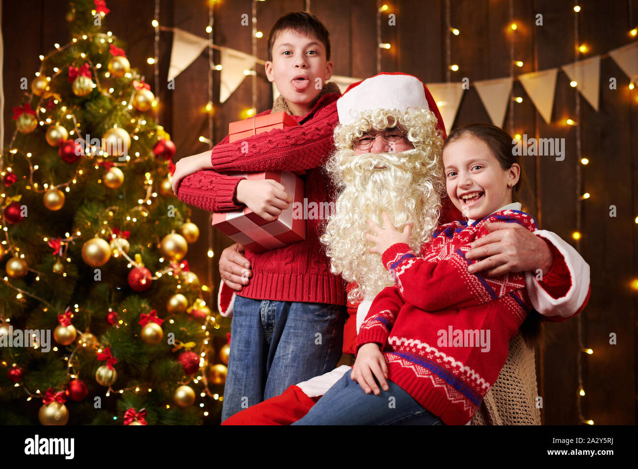 Santa Claus and child boy and girl posing together indoor near ...