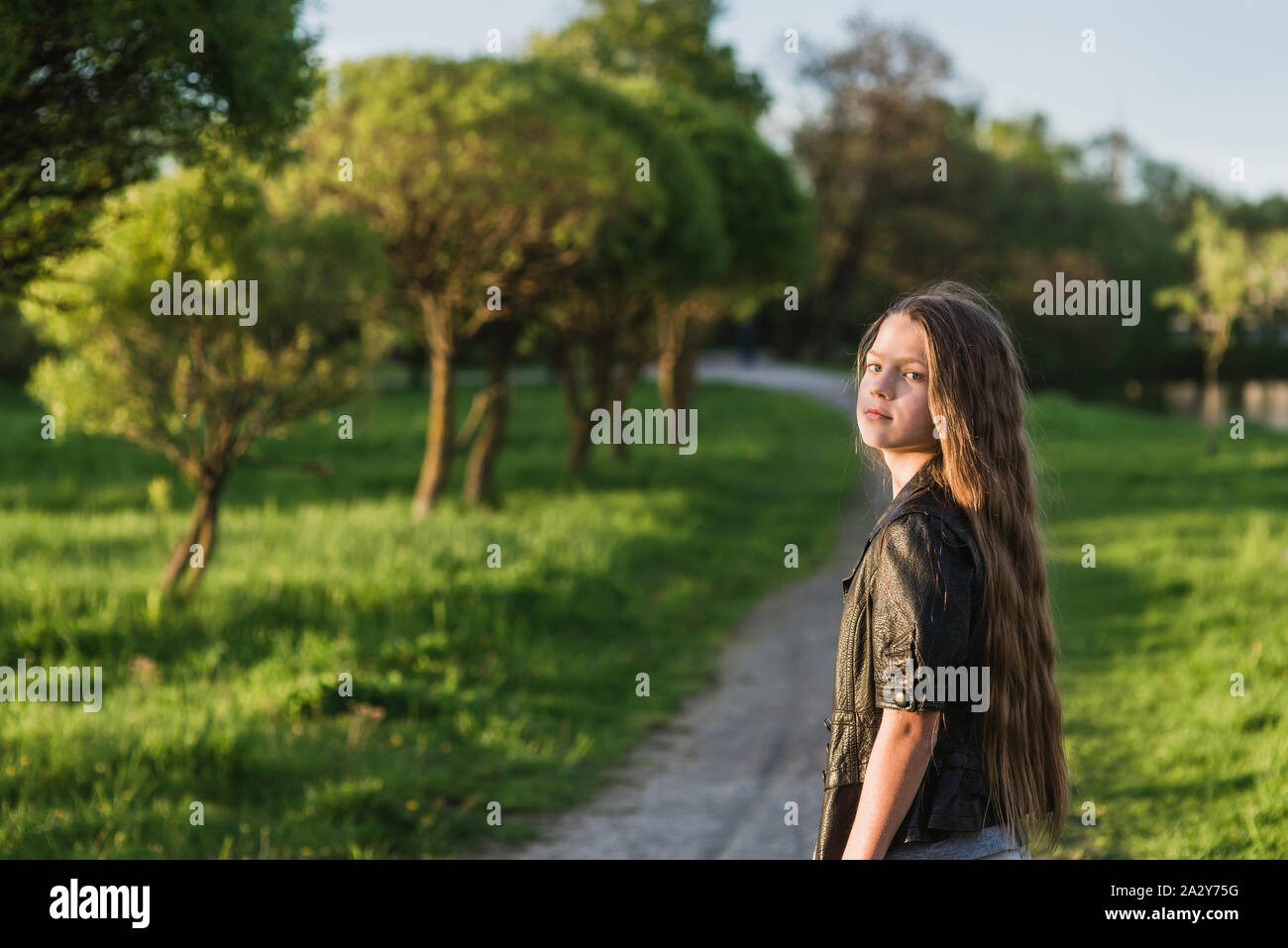 looking back portrait of young girl walking away by evening country ...