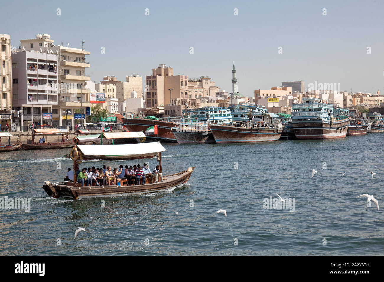 Traditional abra ferry boats on Dubai Creek with Deira city area on ...