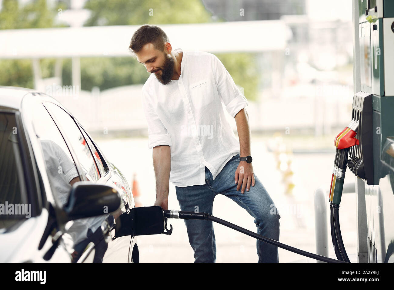Man fueling his car at a self service petroleum gas station hi-res ...