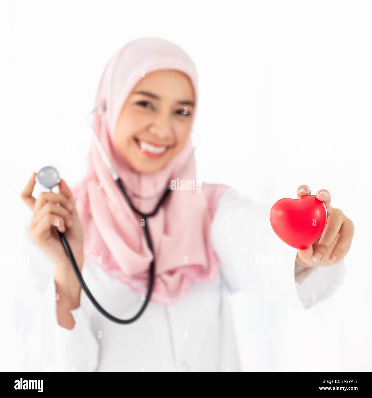 Portrait of beautiful young Muslim woman doctor shows a red heart on ...