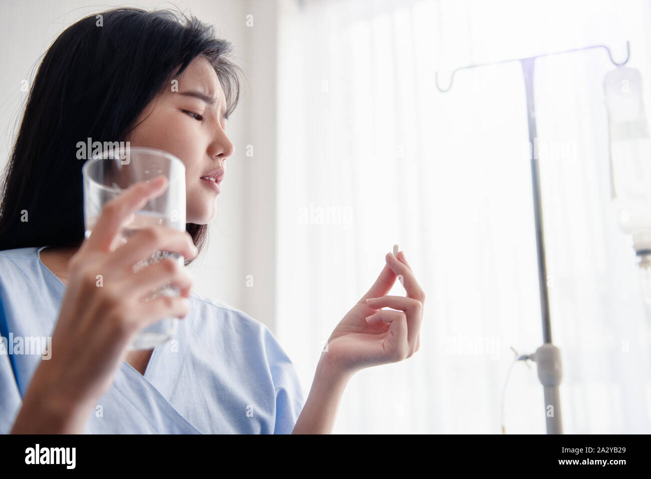 Young Asian beautiful patients women are illness and have a bottle of ...