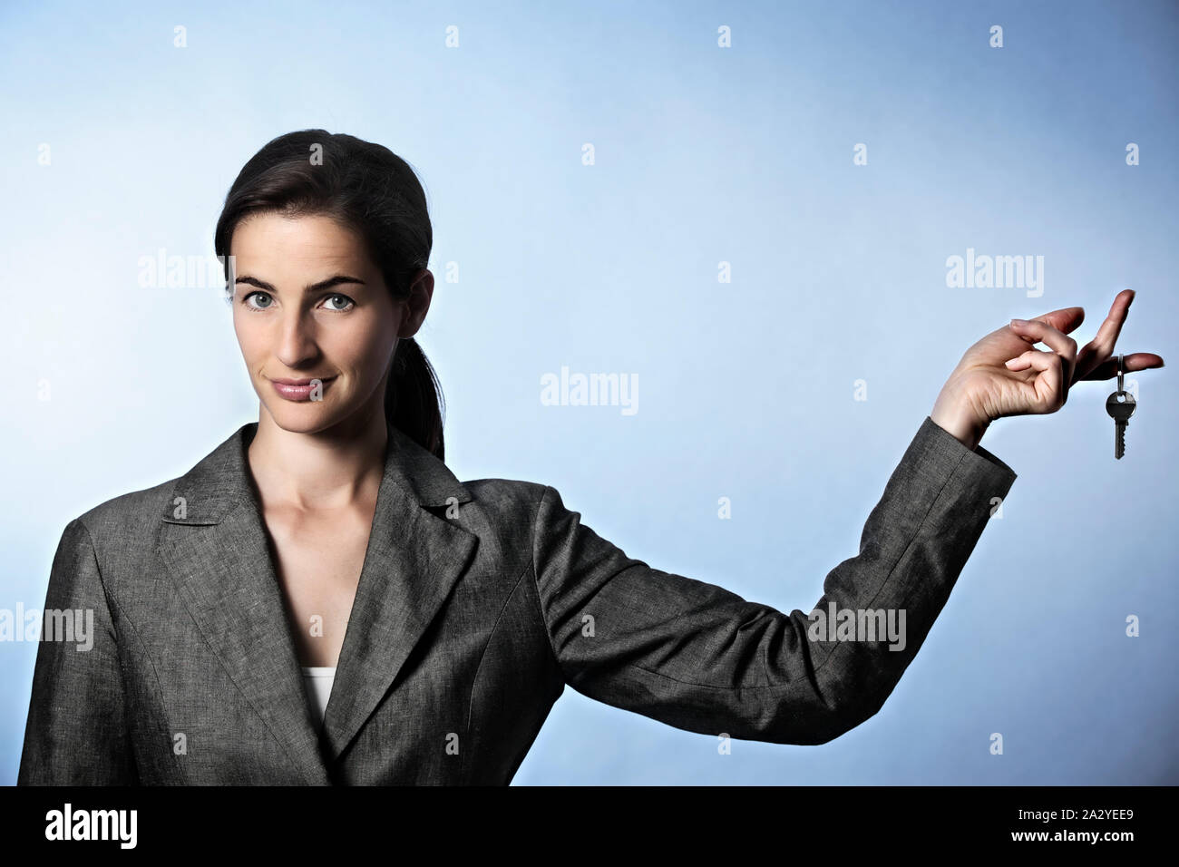 Unlock opportunities: woman holding key between fingers Stock Photo - Alamy