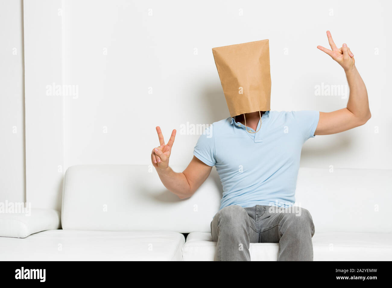 Man with head hidden in paper bag showing victory sign Stock Photo - Alamy