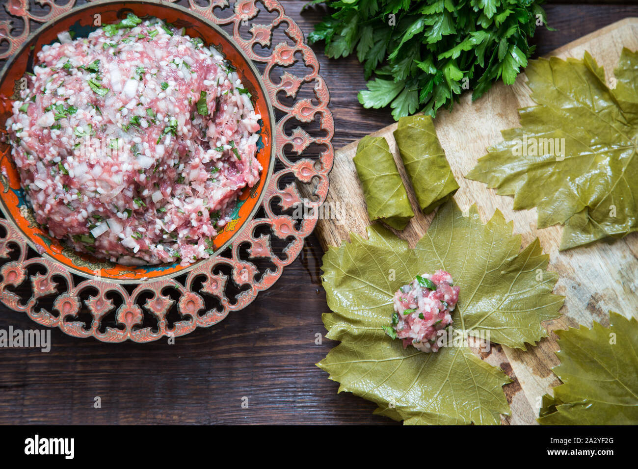 preparing stuffed vine leaves with rice and meat, or traditional Dolma ...