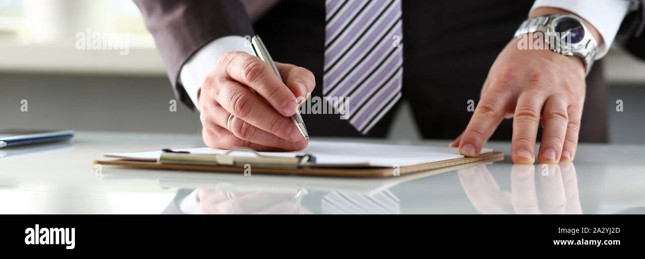 Male arm in suit and tie fill form clipped to pad Stock Photo - Alamy