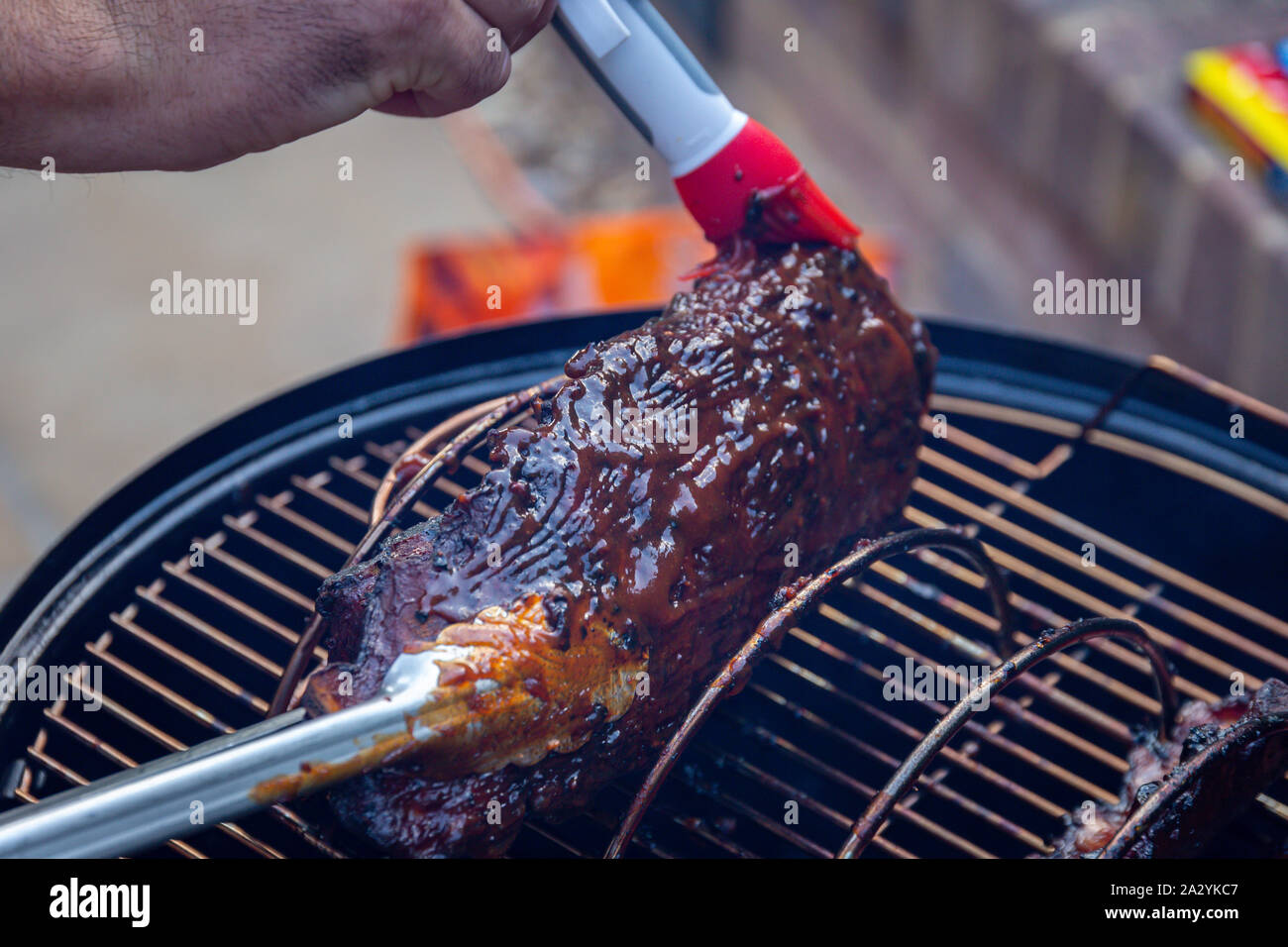 Cooking marinated baby back ribs on an outdoor barbecue Stock Photo - Alamy