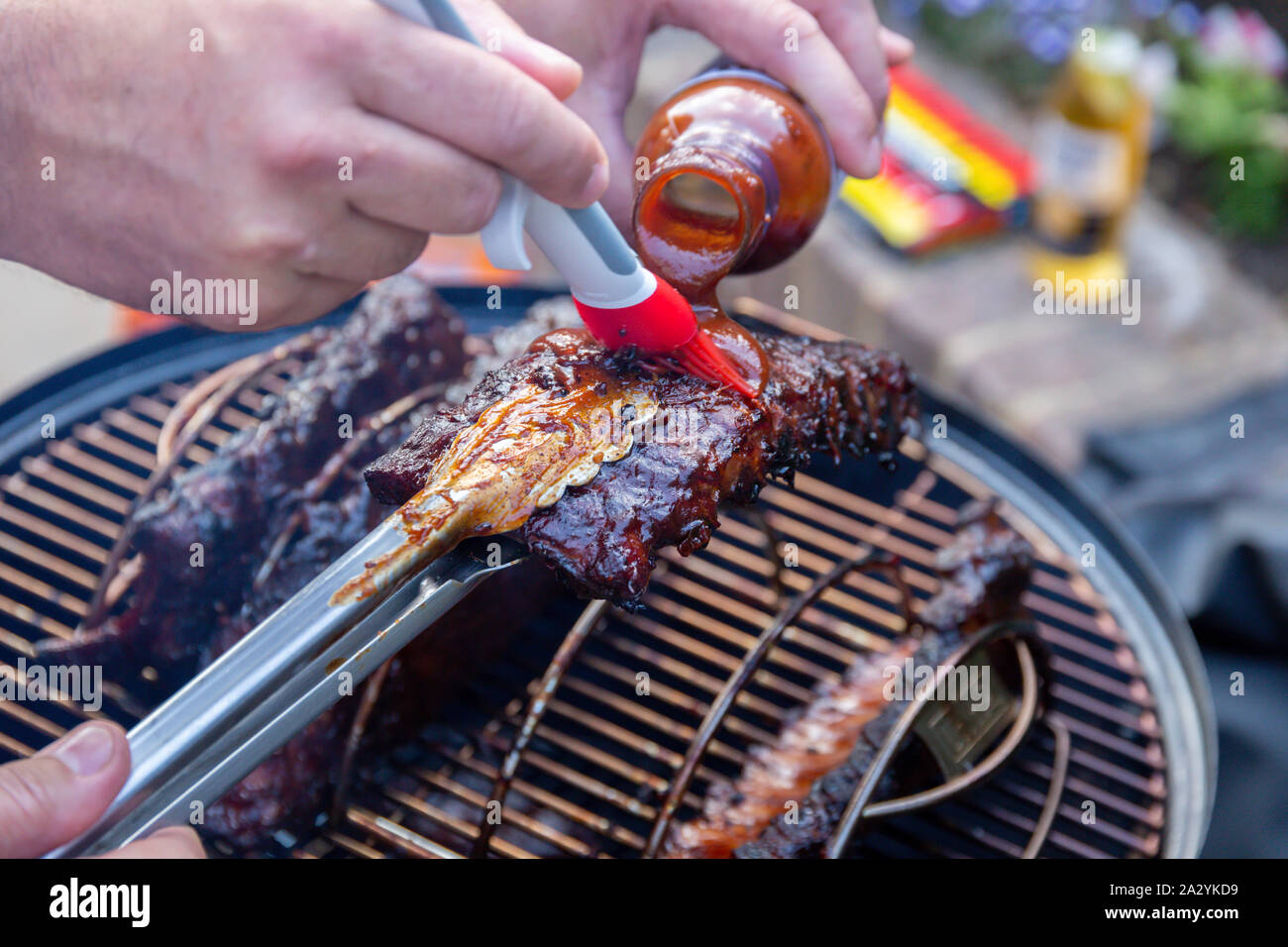 Cooking marinated baby back ribs on an outdoor barbecue Stock Photo - Alamy