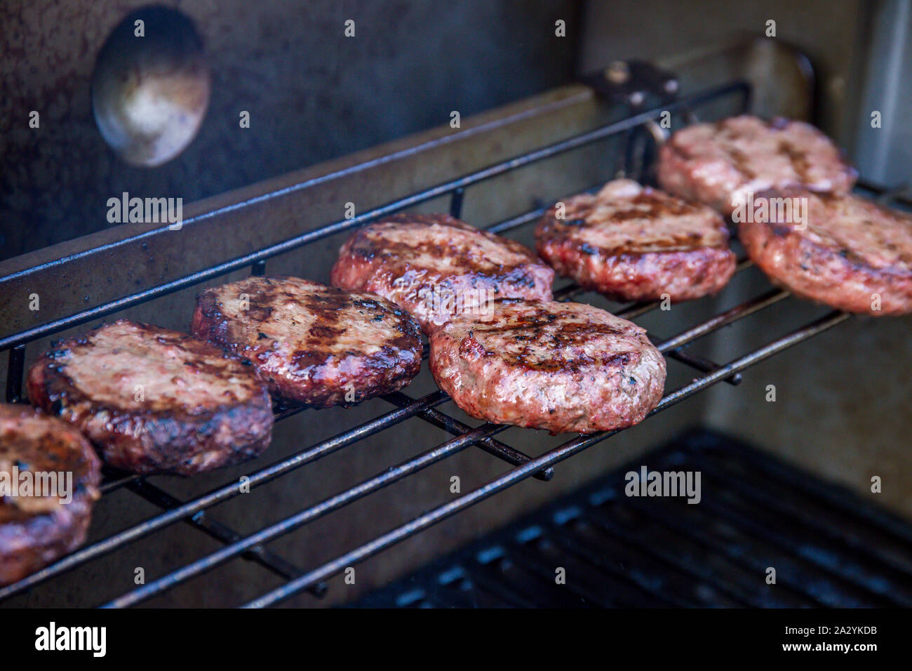 Juicy barbecued beef burgers on a barbecue warming rack Stock Photo - Alamy
