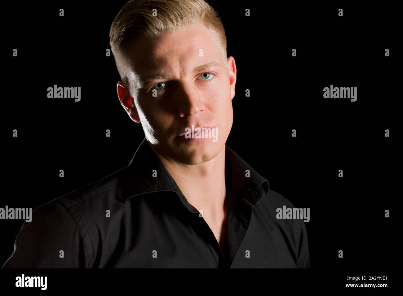 Low key portrait of charming man looking straight Stock Photo - Alamy