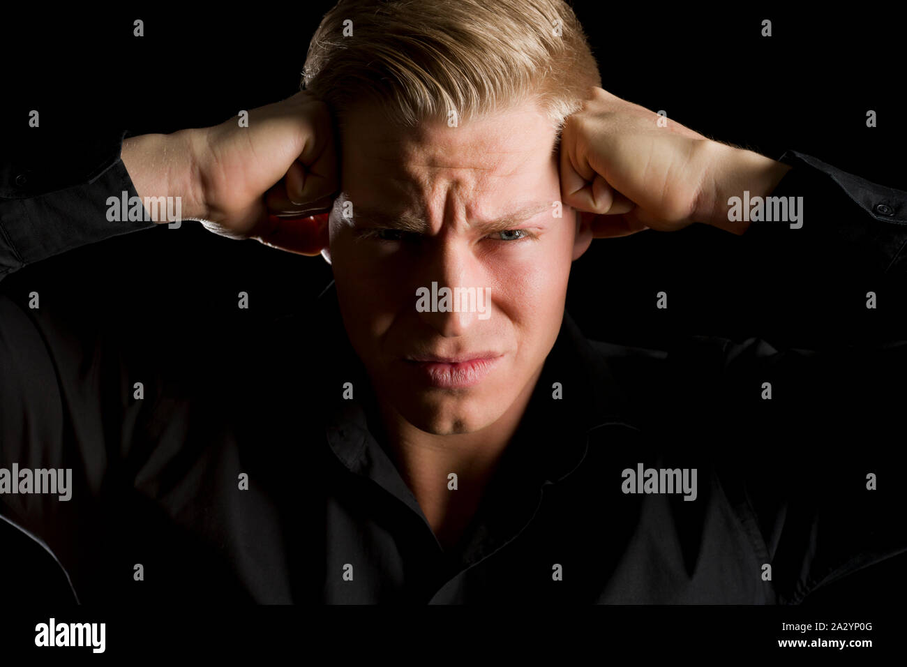 Low key portrait of overburdened young man Stock Photo - Alamy