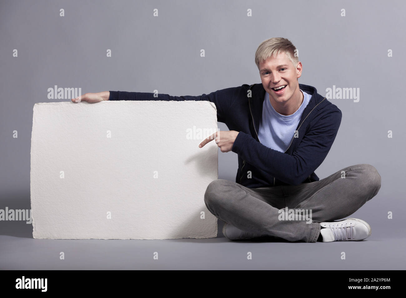 Friendly man pointing finger at blank signboard Stock Photo - Alamy