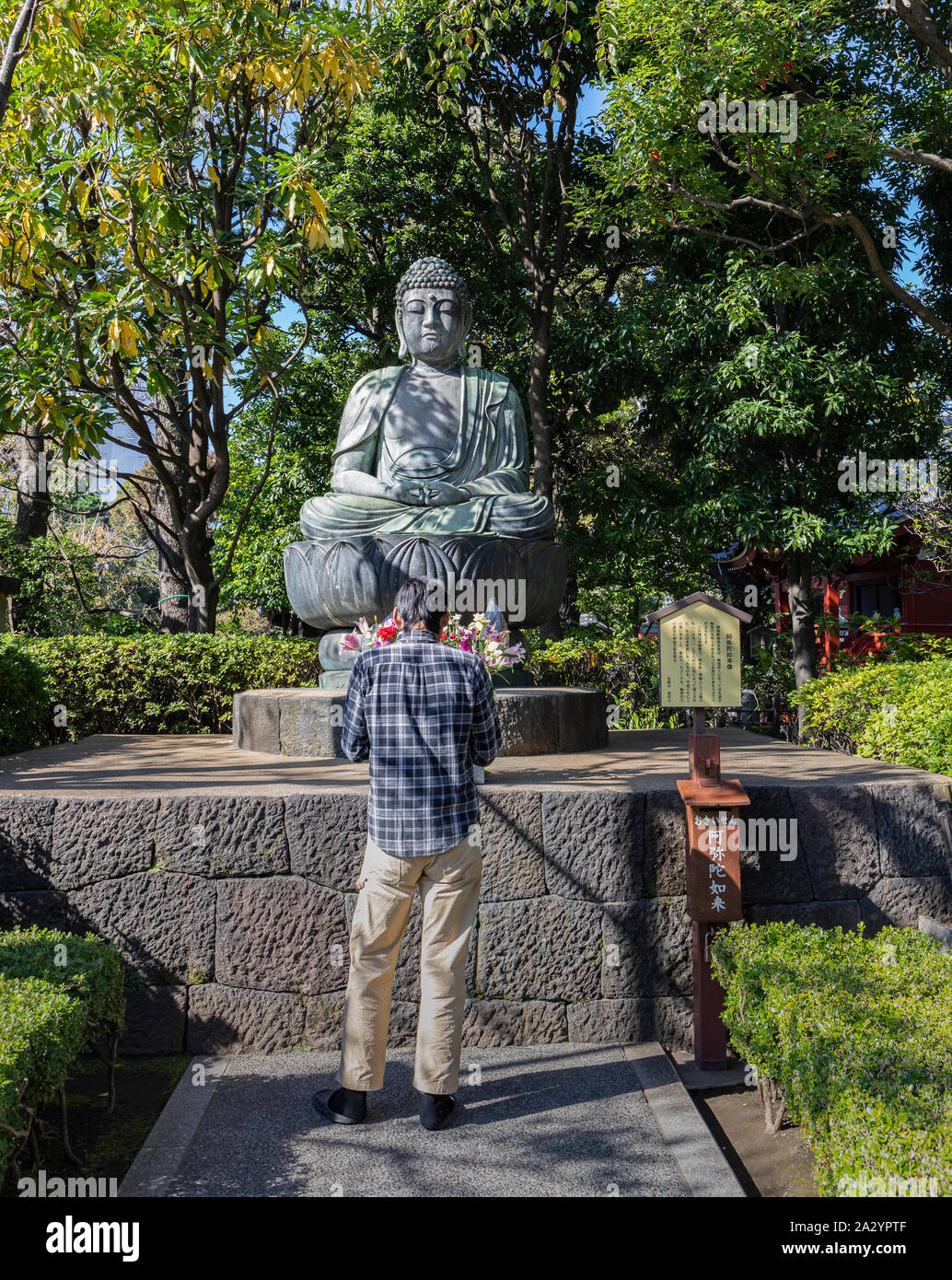 Tokyo, Japan - October 30th, 2018: A man praying in front of a Buddha ...