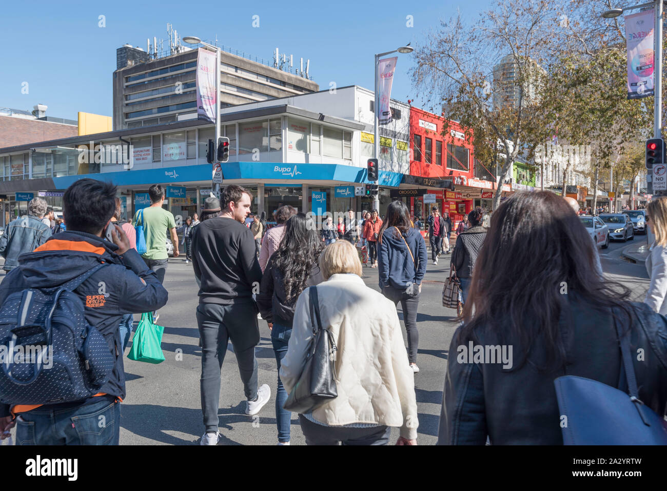 A large group of people crossing a road at an intersection in the ...