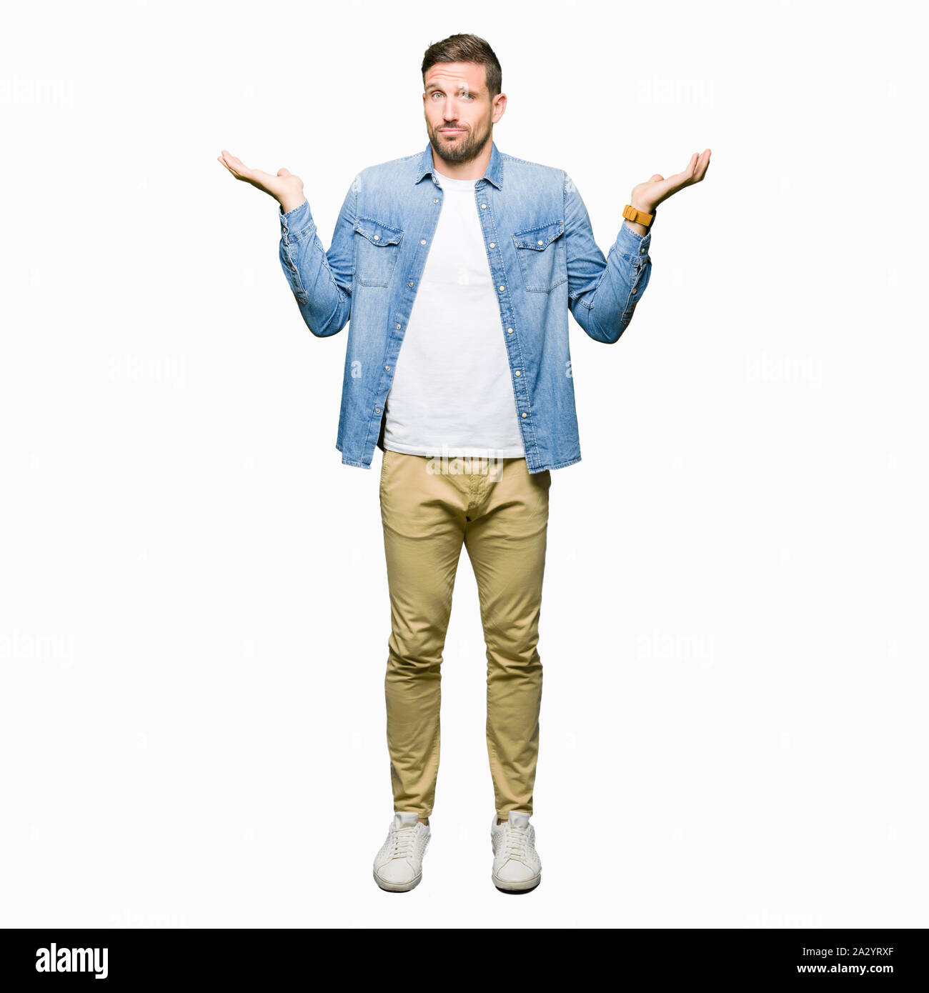 Handsome man with blue eyes and beard wearing denim jacket clueless and ...