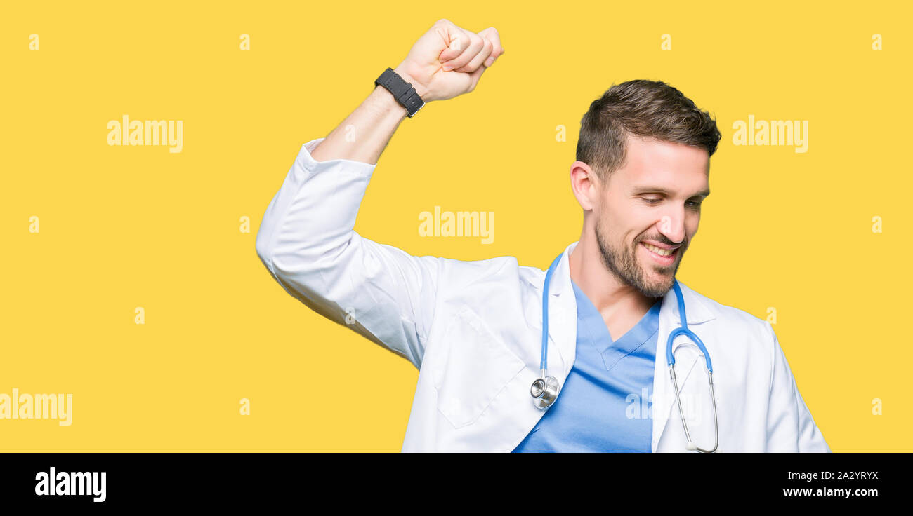 Handsome doctor man wearing medical uniform over isolated background ...