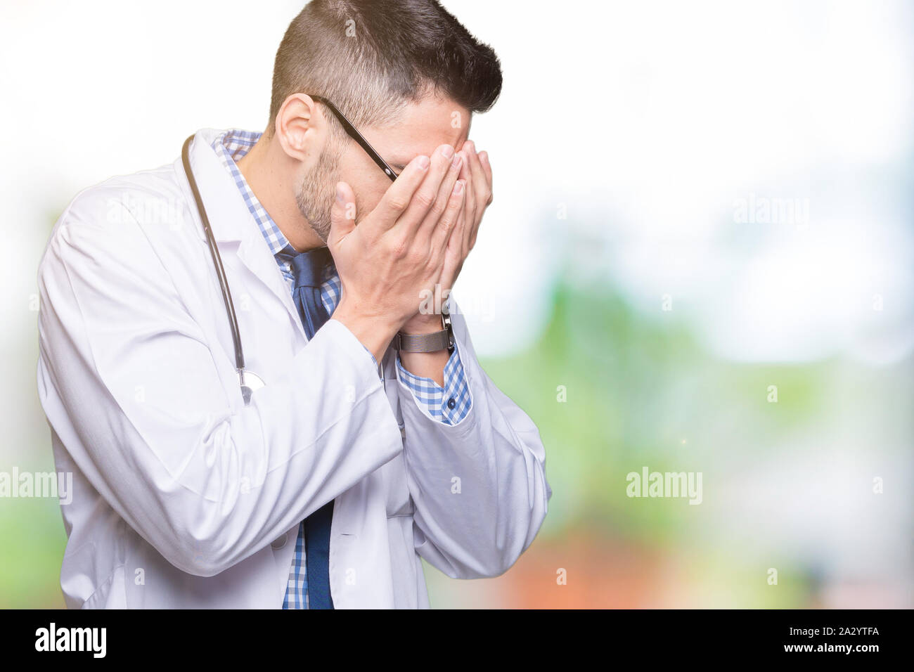 Handsome young doctor man over isolated background with sad expression ...